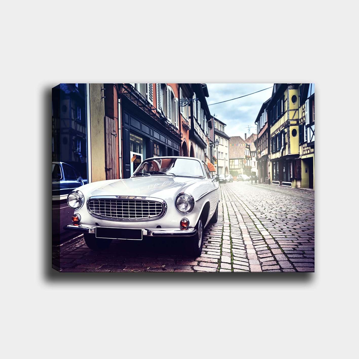 Lærred 70x100 cm - Klassisk hvid bil parkeret på en charmerende, gammeldags gade med historiske ...